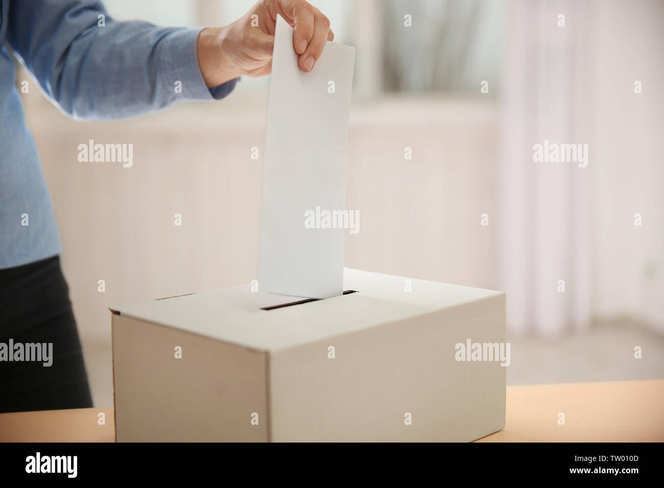 Closeup of hand inserting envelope in ballot box Stock Photo - Alamy