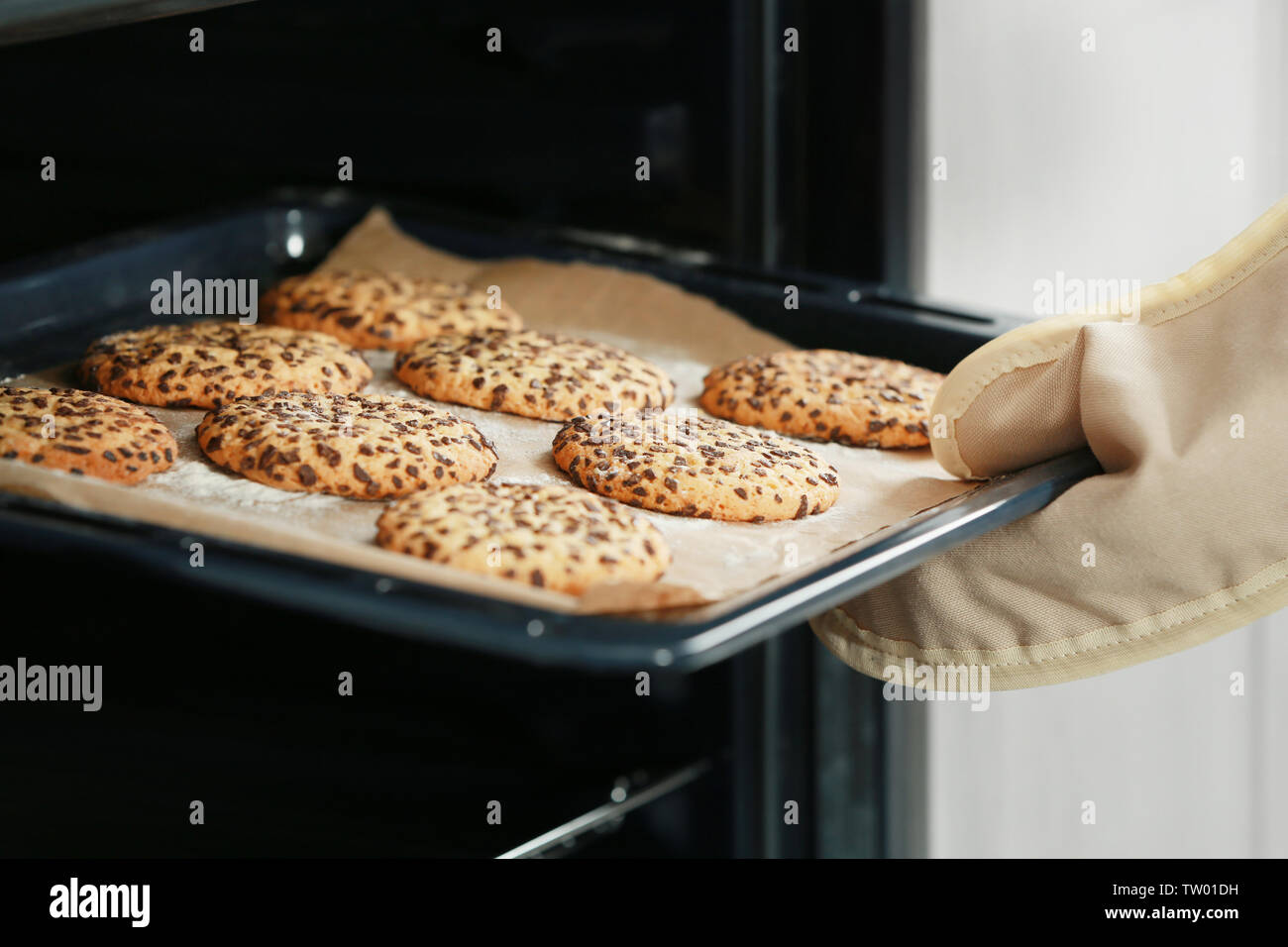 Woman taking out freshly baked cookies Stock Photo - Alamy