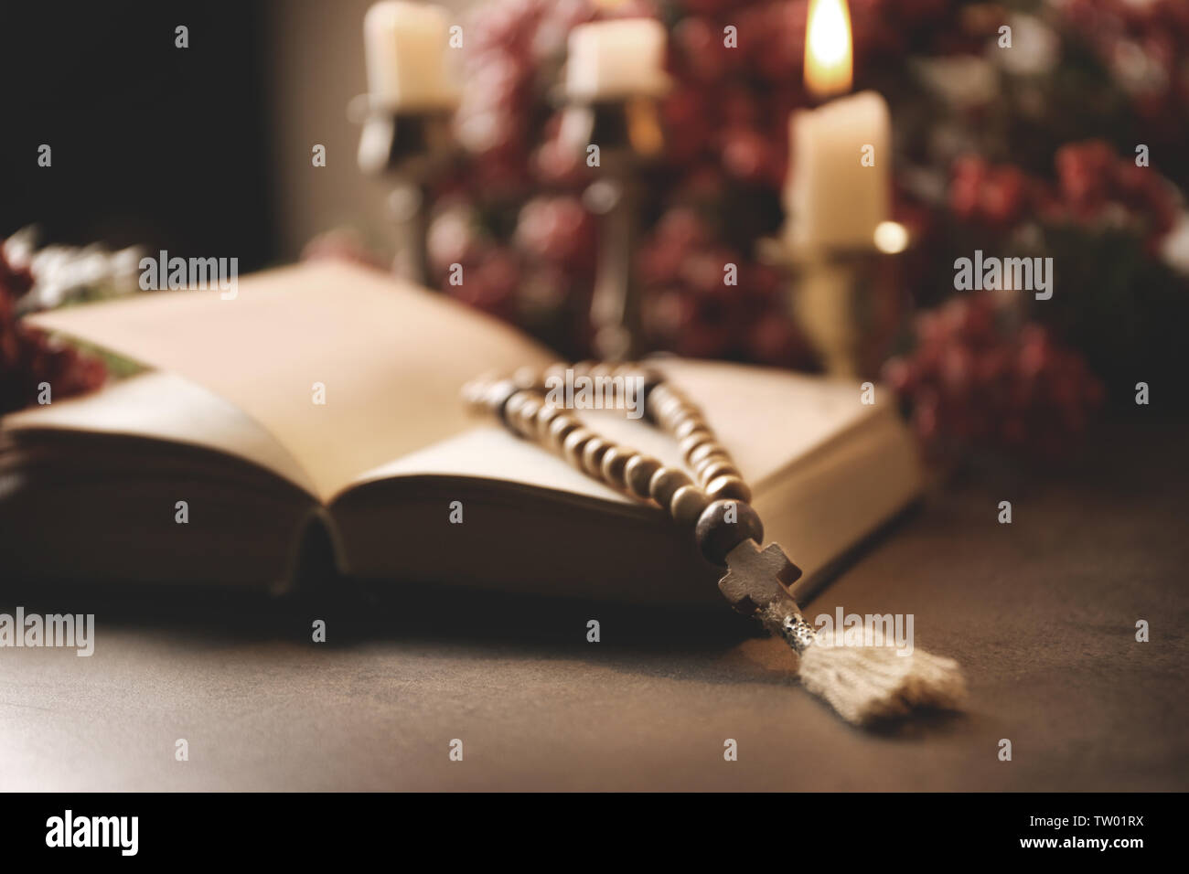 Open Bible and wooden rosary beads on table Stock Photo - Alamy