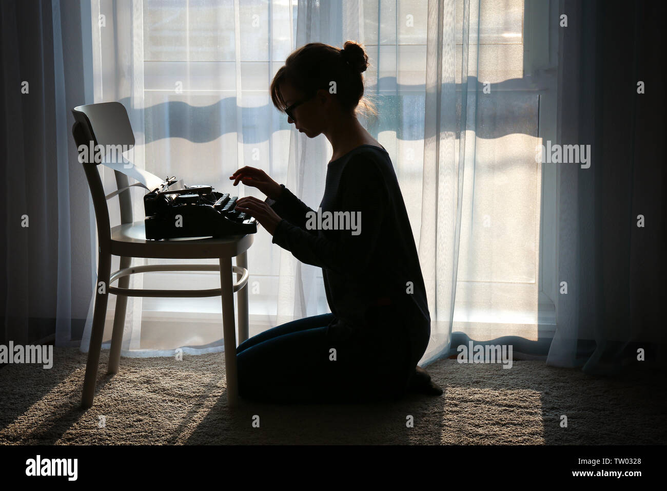Girl typing on a typewriter Stock Photo - Alamy