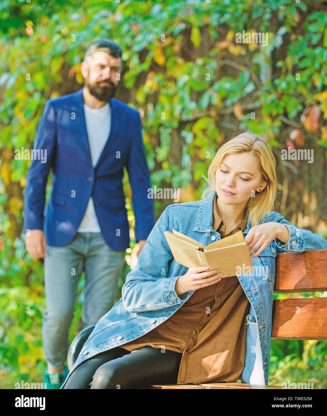 romantic couple meet in park. woman read intersting book. relax on park ...