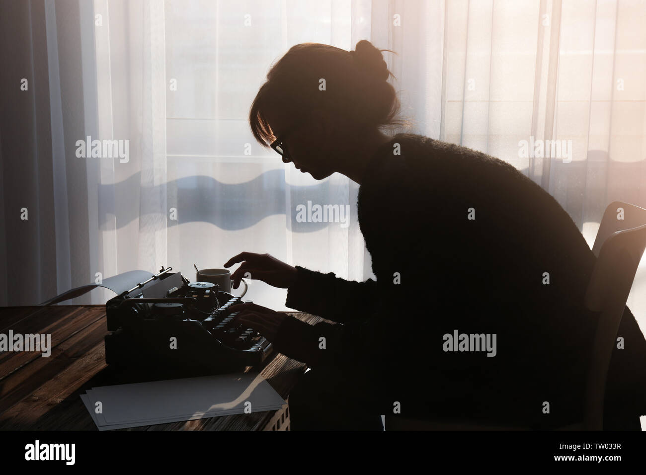 Girl typing on a typewriter Stock Photo - Alamy