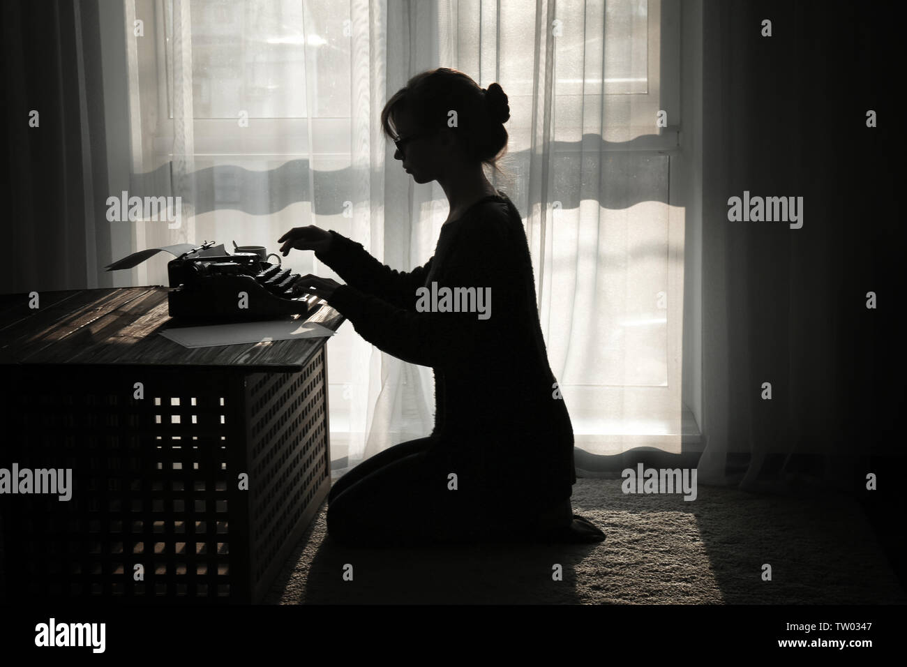 Girl typing on a typewriter Stock Photo - Alamy