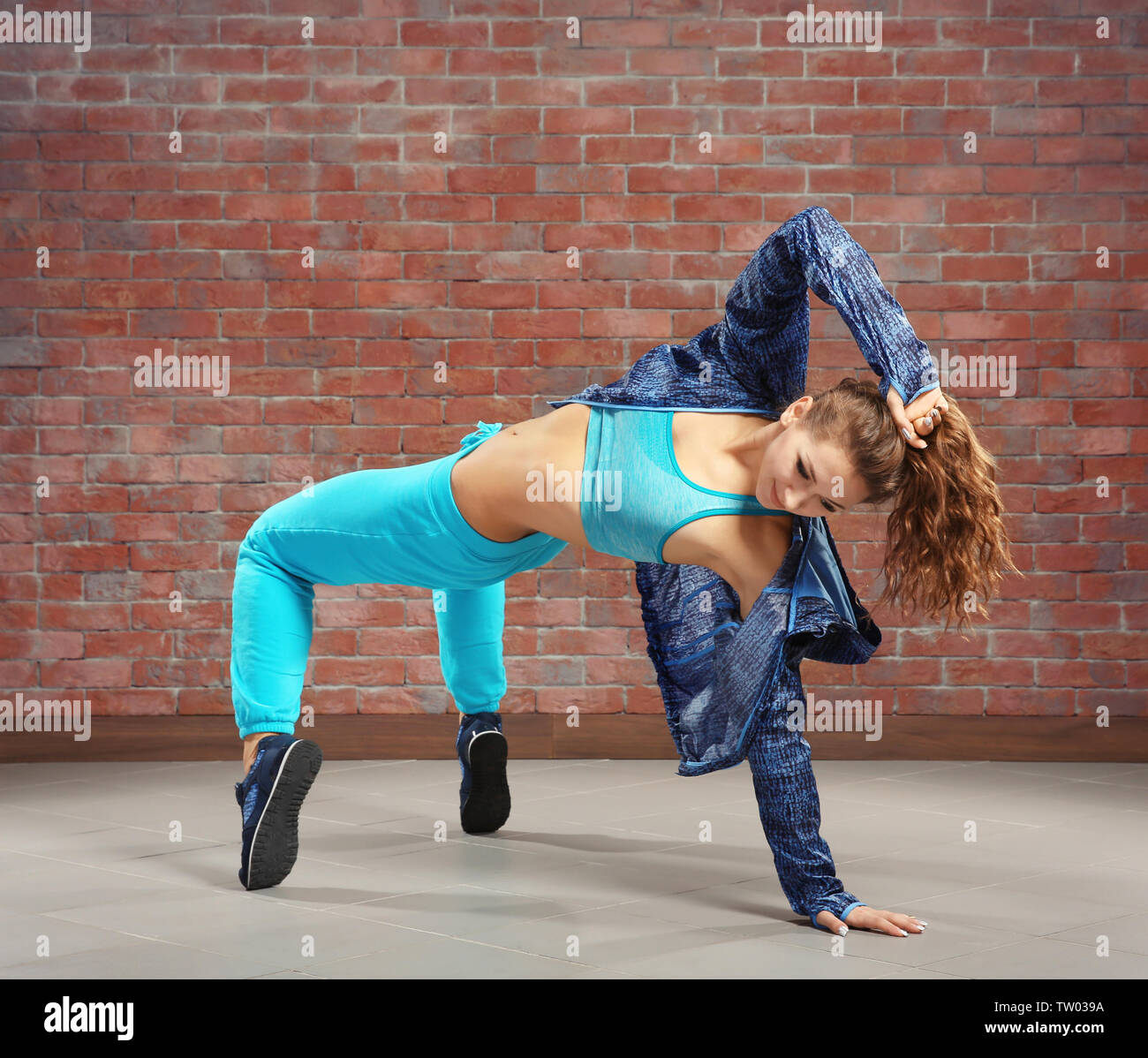 Beautiful young hip-hop dancer against brick wall Stock Photo - Alamy