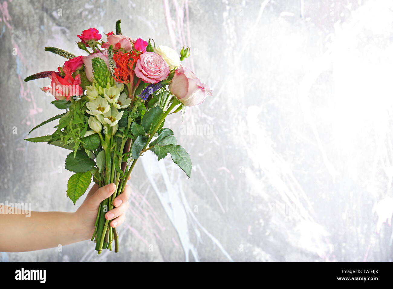 Woman hand holding bouquet of fresh flowers on light background Stock ...