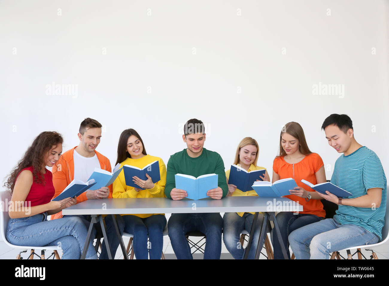Group of people reading books while sitting at table Stock Photo - Alamy