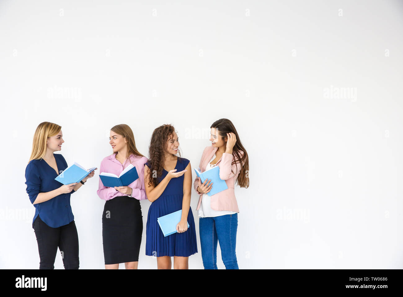 Beautiful young women with books on light background Stock Photo - Alamy