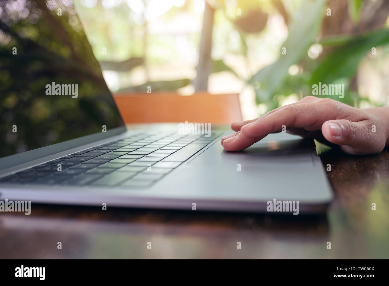 Closeup image of hand using and touching on laptop touchpad on wooden ...