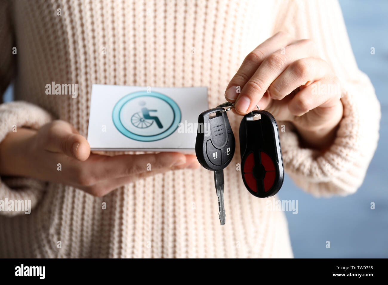 Woman holding car key and card with handicap sign, closeup Stock Photo ...