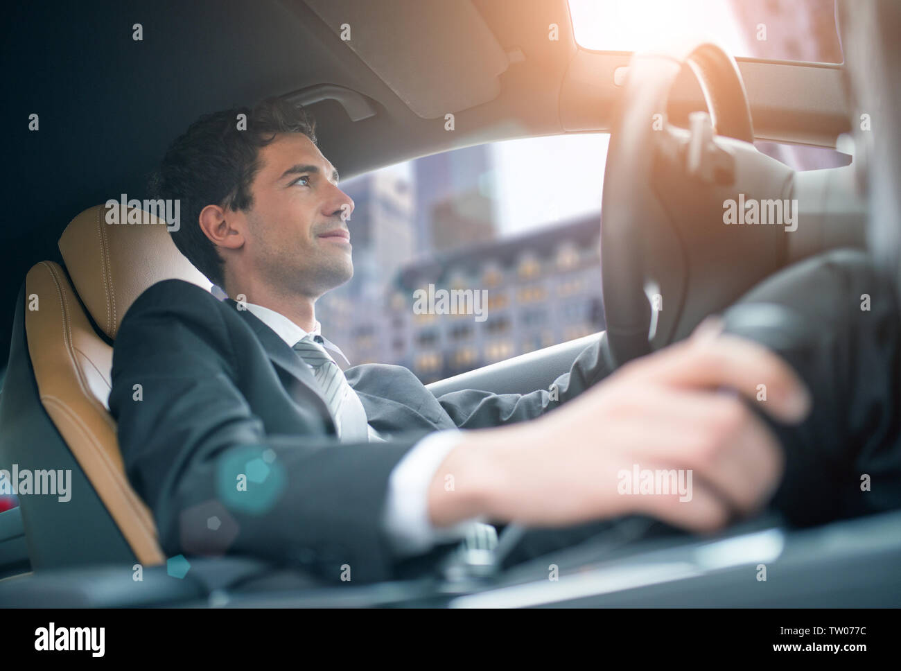 Man driving his car in a city Stock Photo - Alamy