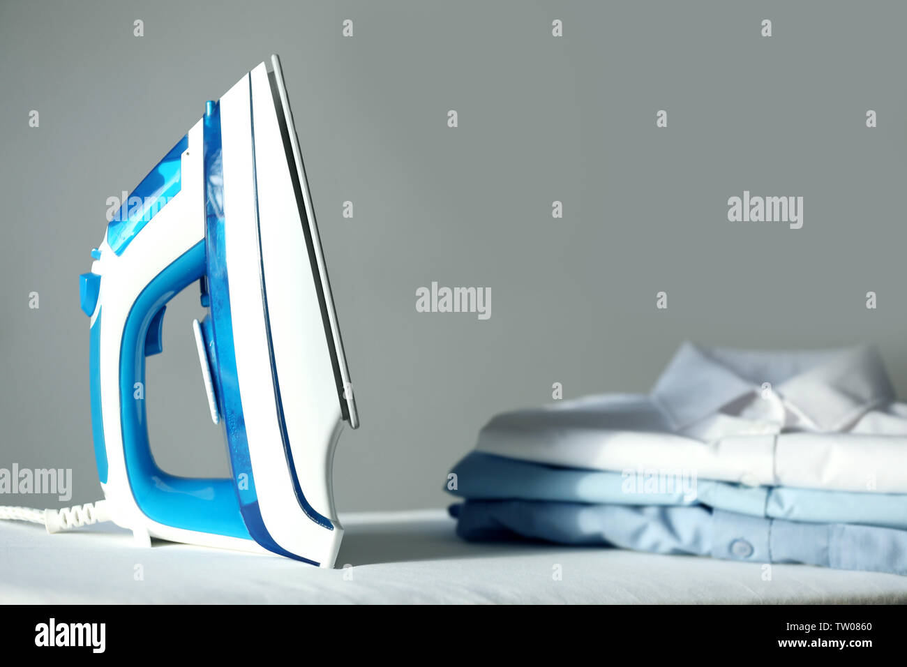 Modern iron and clean clothes on board Stock Photo - Alamy