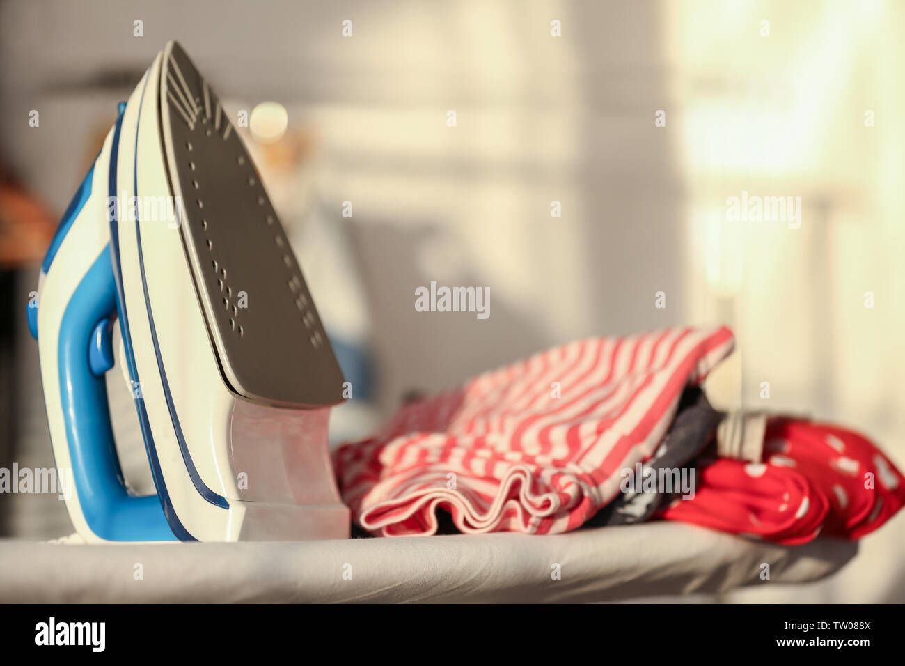 Modern iron and clean clothes on board Stock Photo - Alamy