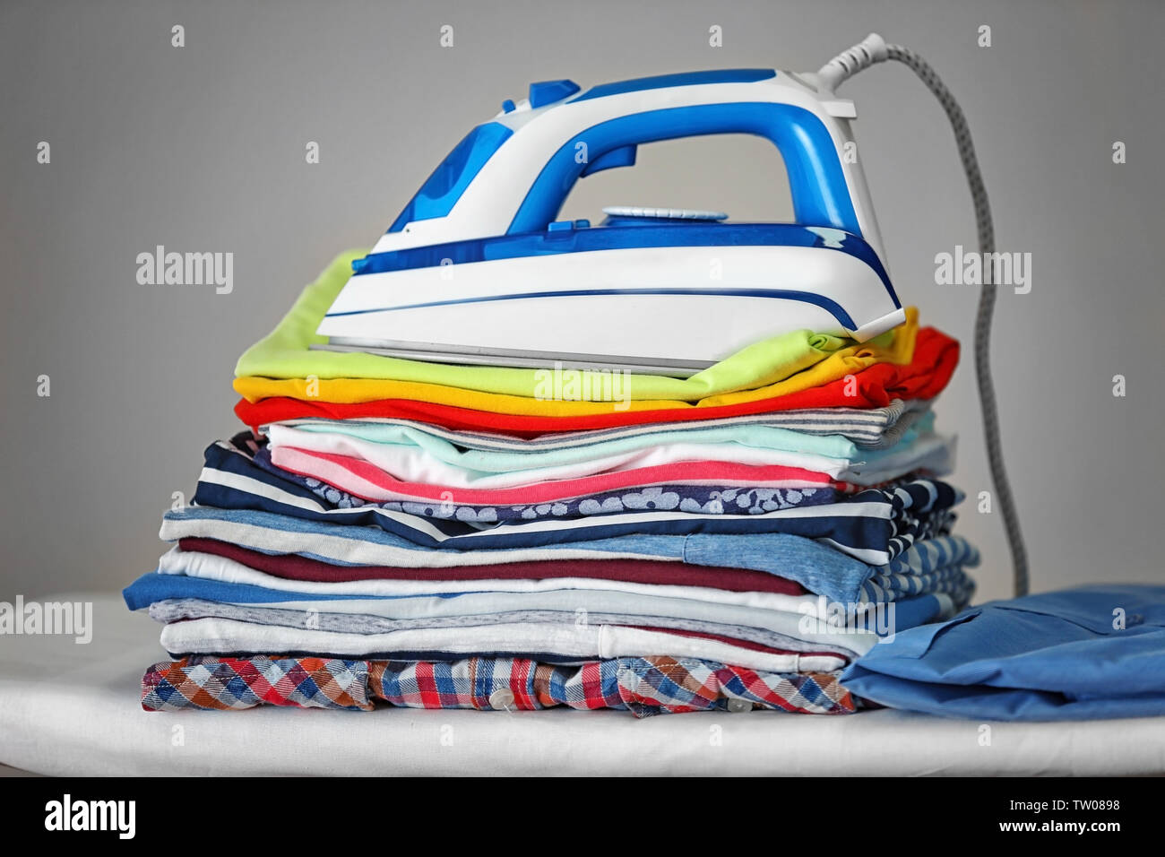 Modern iron and clean clothes on board Stock Photo - Alamy
