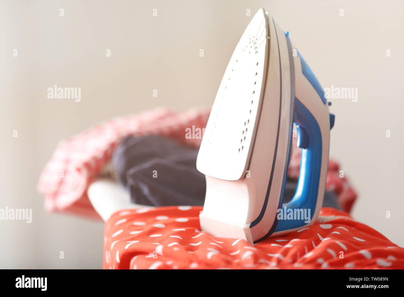 Modern iron and clean clothes on board Stock Photo - Alamy