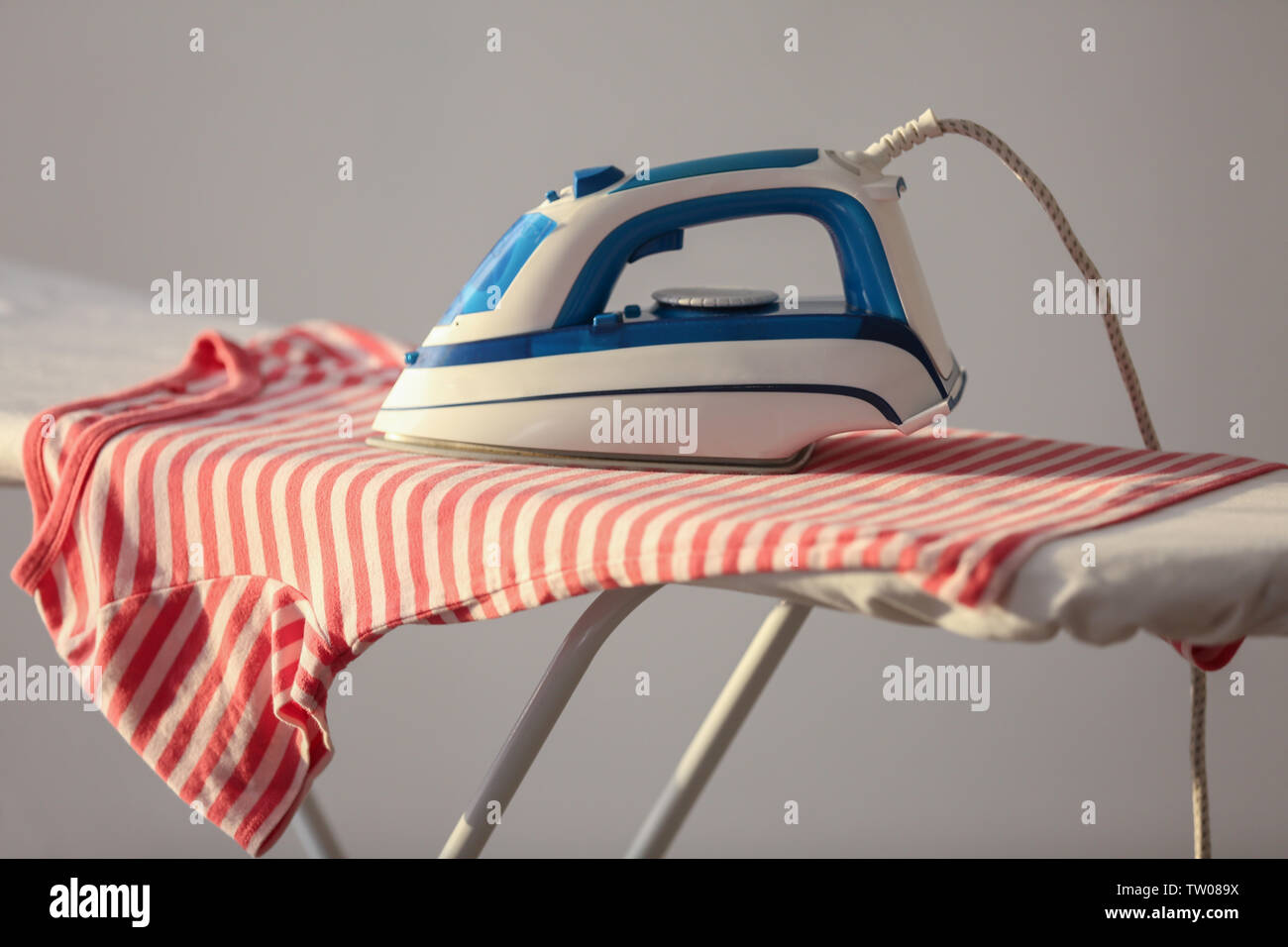 Modern iron and clean clothes on board Stock Photo - Alamy