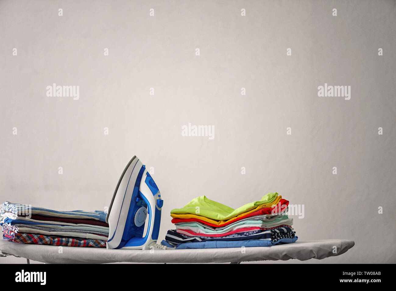 Modern iron and clean clothes on board Stock Photo - Alamy