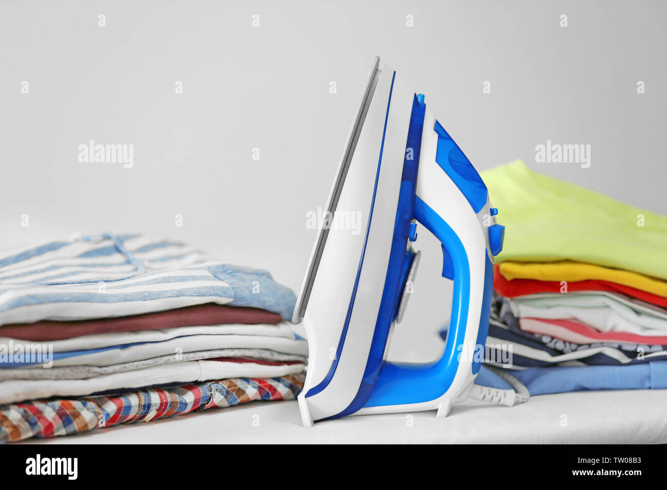 Modern iron and clean clothes on board Stock Photo - Alamy