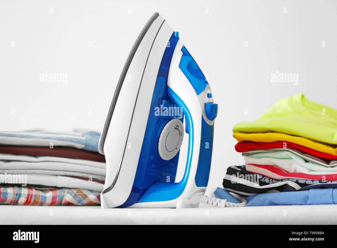 Modern iron and clean clothes on board Stock Photo - Alamy