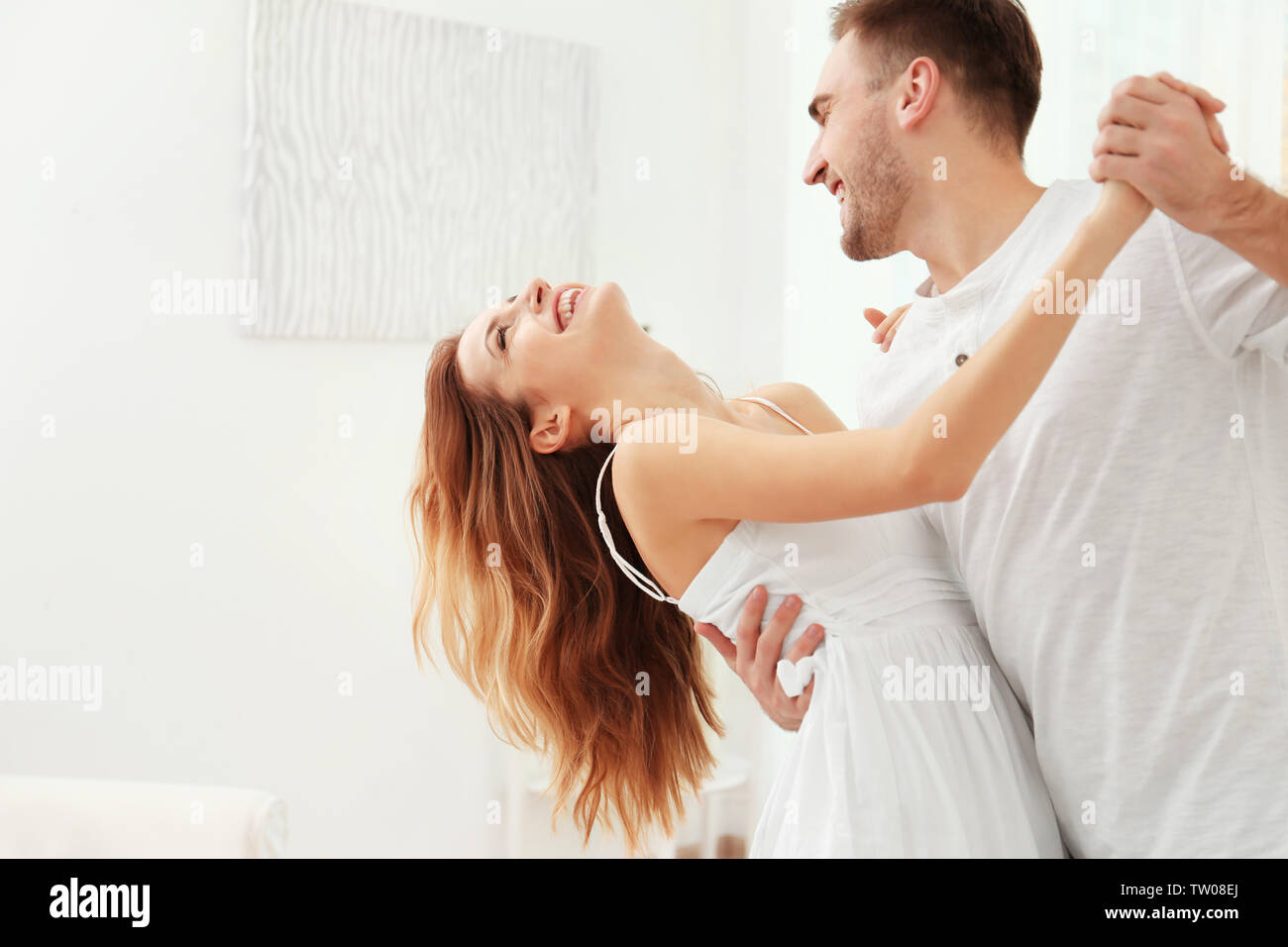 Cute young couple dancing at home Stock Photo - Alamy