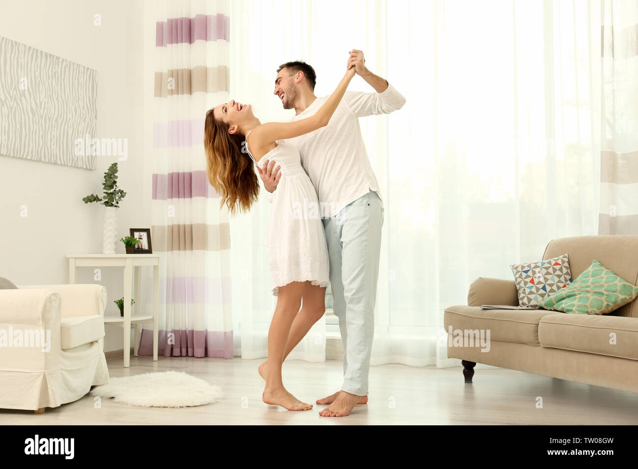 Cute young couple dancing at home Stock Photo - Alamy