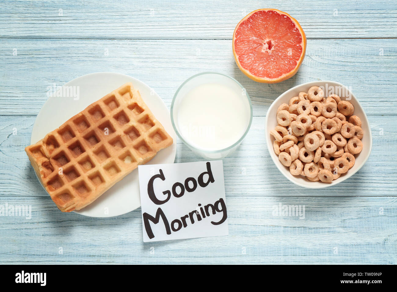 Note with written phrase GOOD MORNING and tasty breakfast on table ...