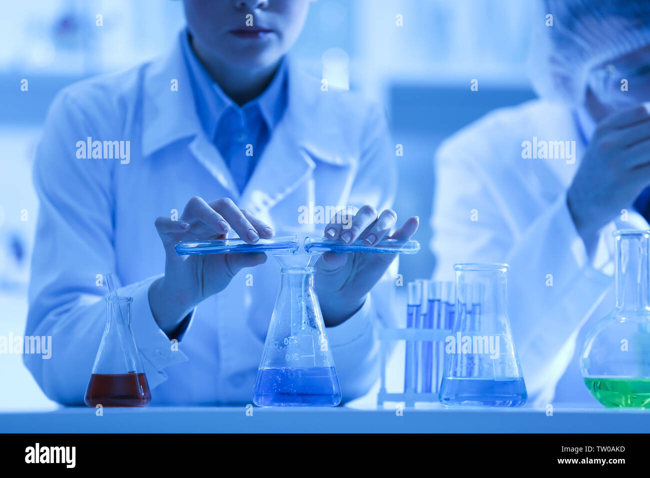 Female scientists pouring chemical hi-res stock photography and images ...