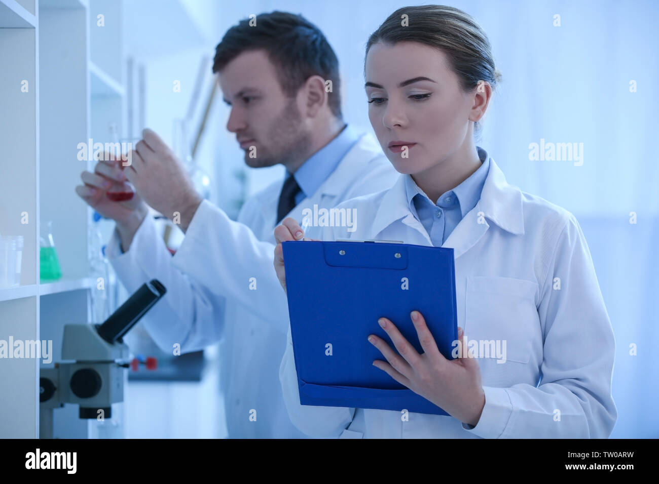 Female and male scientists working in a laboratory Stock Photo - Alamy