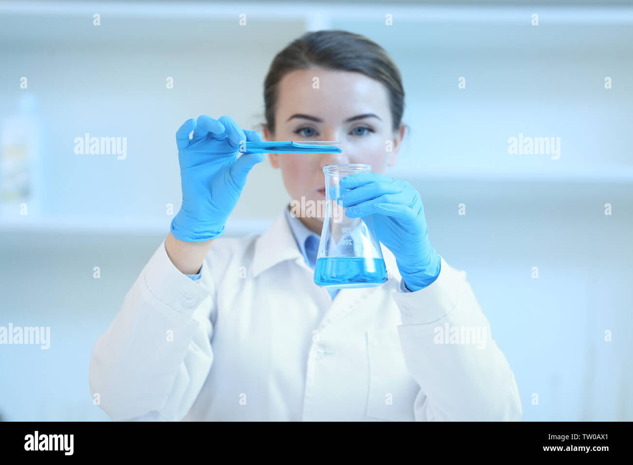 Scientist pouring a sample into a test flask Stock Photo - Alamy