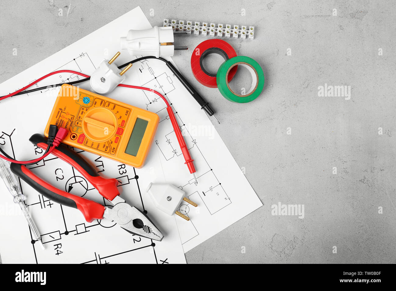 Electrician tools and schemes on grey background Stock Photo - Alamy