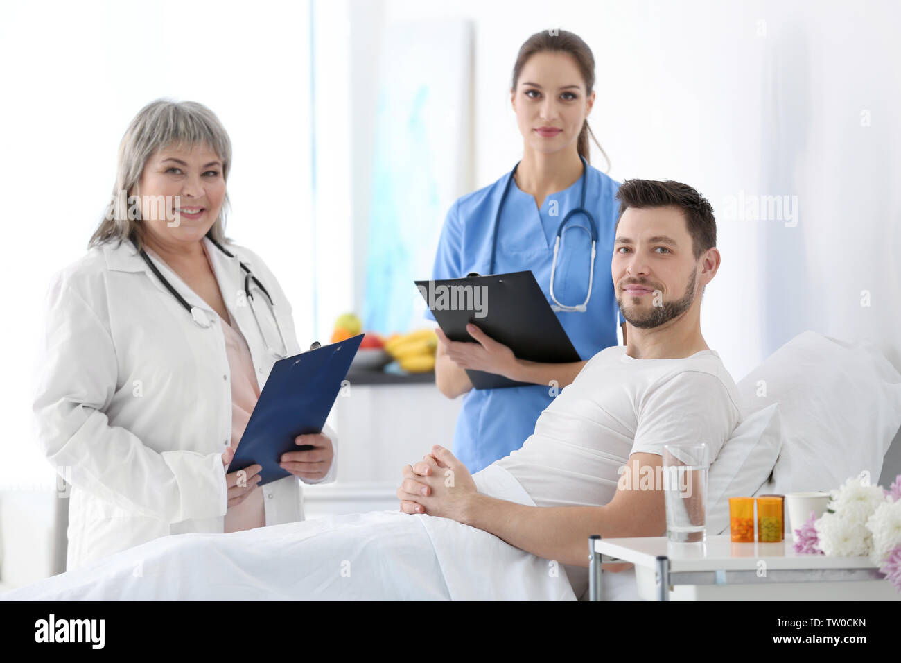 Doctors visiting patient in hospital Stock Photo - Alamy