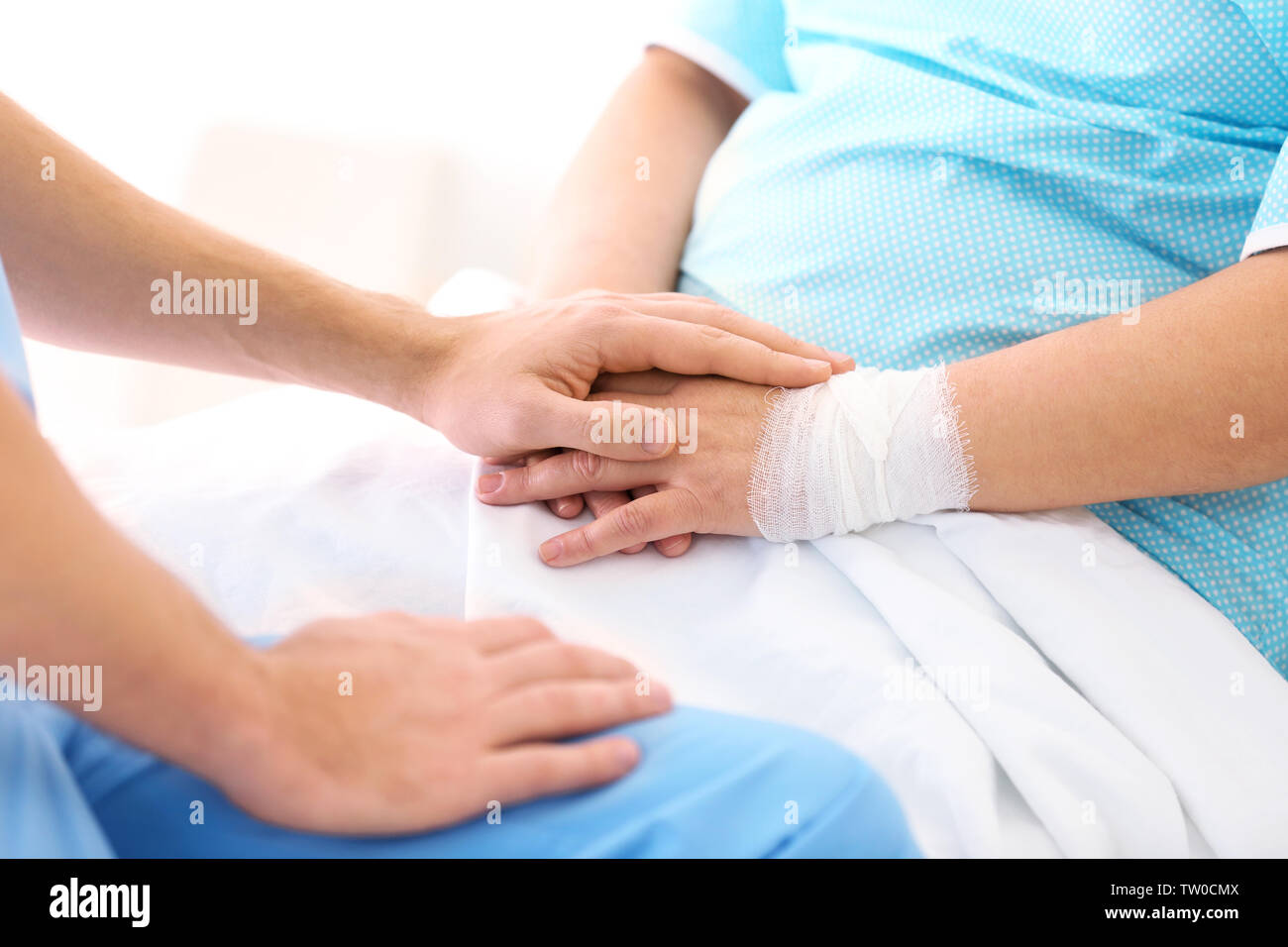 Closeup of doctor holding patient's hands in hospital Stock Photo - Alamy