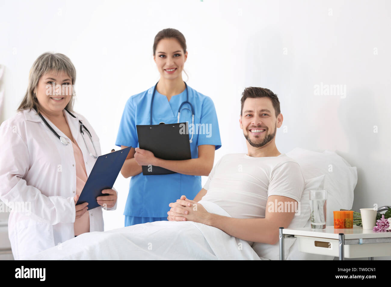 Doctors visiting patient in hospital Stock Photo - Alamy
