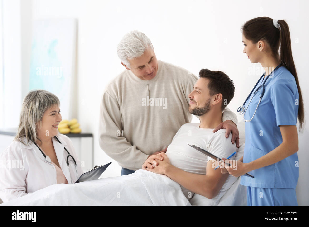Doctors visiting patient in hospital Stock Photo - Alamy