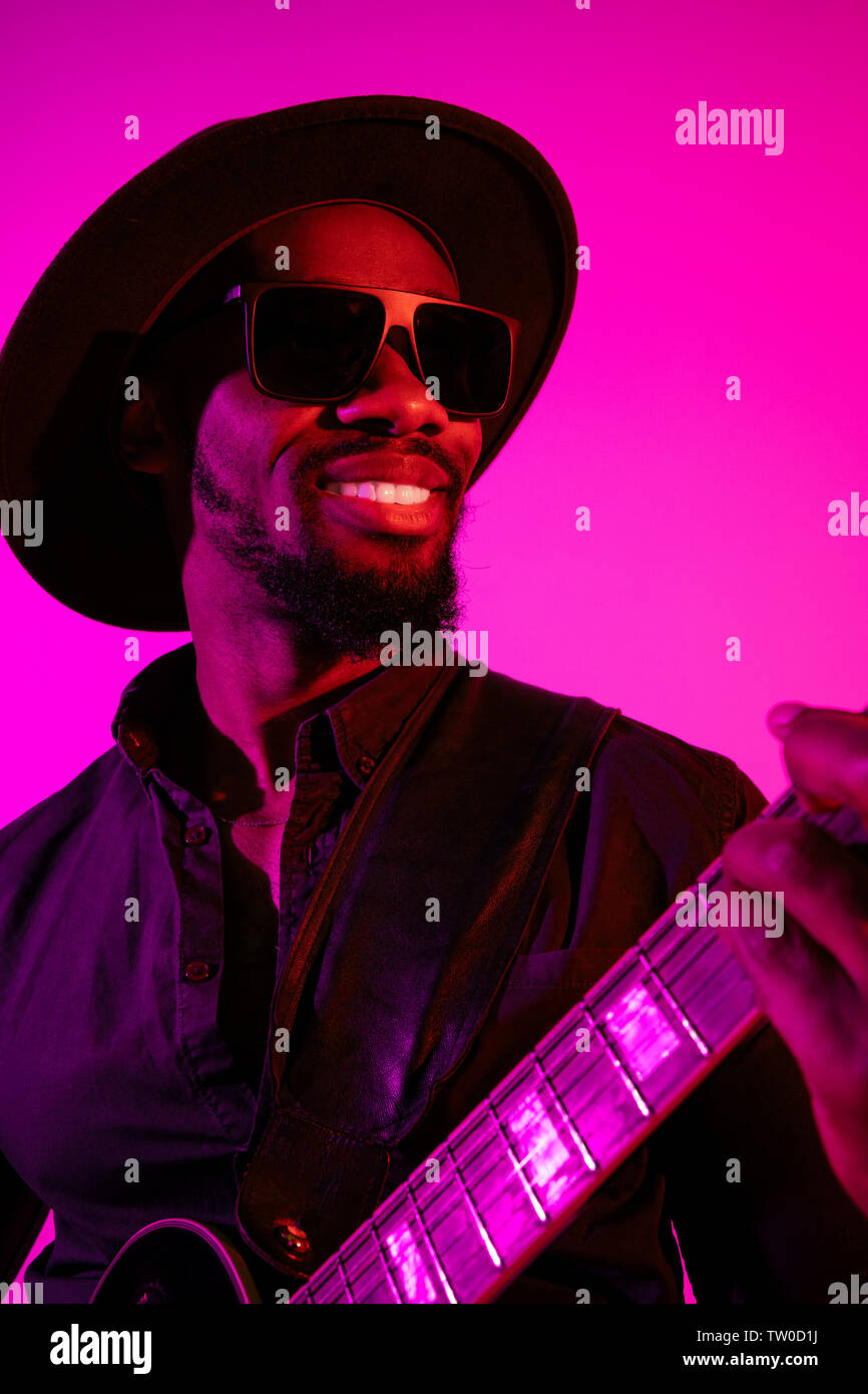 Young african-american musician playing the guitar like a rockstar on ...