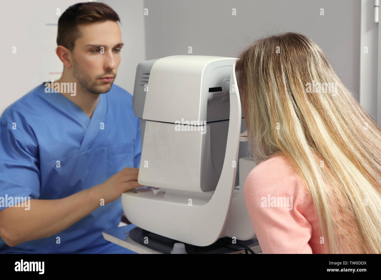 Ophthalmologist measuring intraocular pressure of young woman in clinic ...