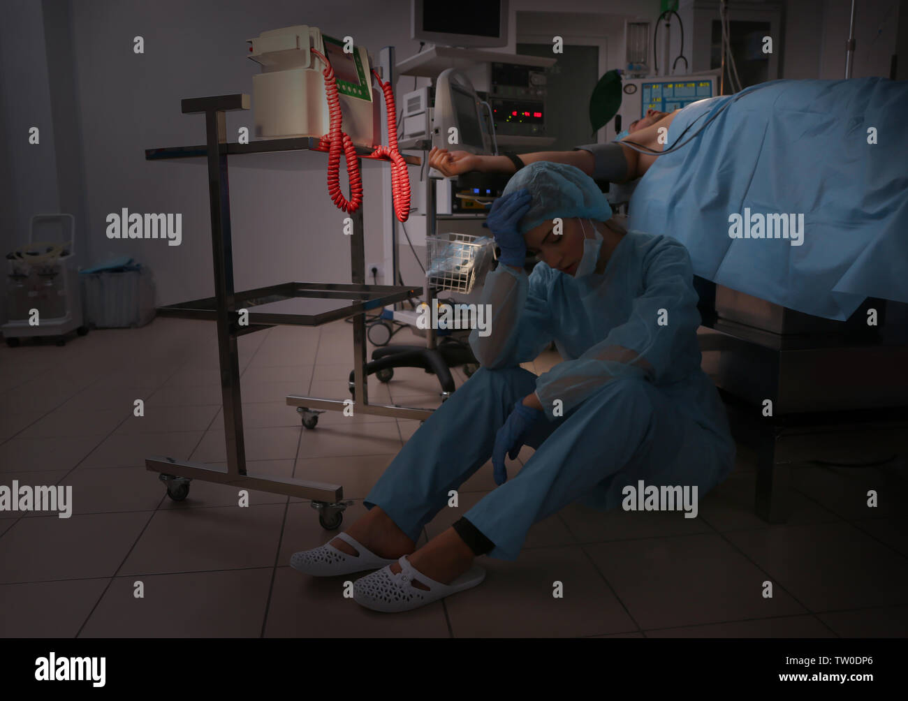 Sad doctor sitting on floor after failed operation in clinic Stock ...