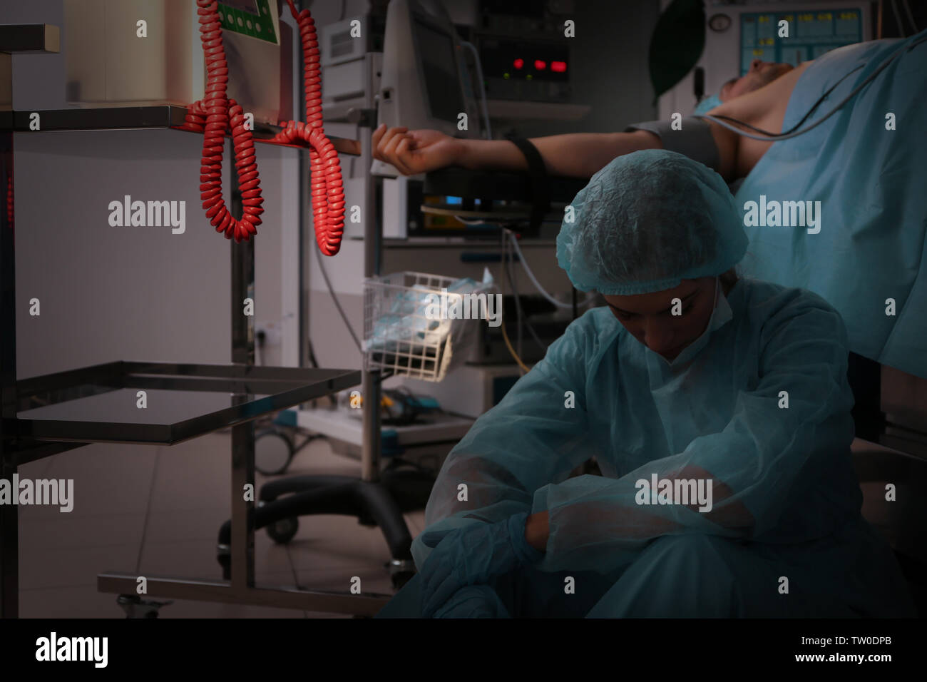 Sad doctor sitting on floor after failed operation in clinic Stock ...
