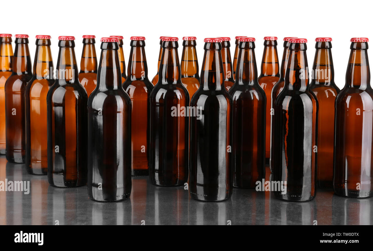 Bottles of beer on table against white background Stock Photo - Alamy