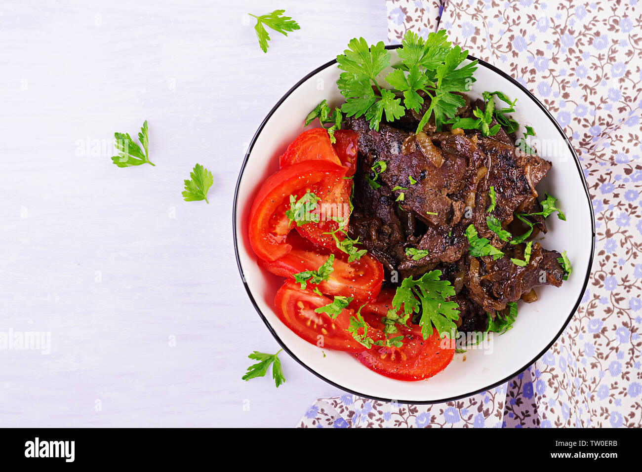 Roasted or grilled beef liver with onion and tomatoes salad. Middle ...