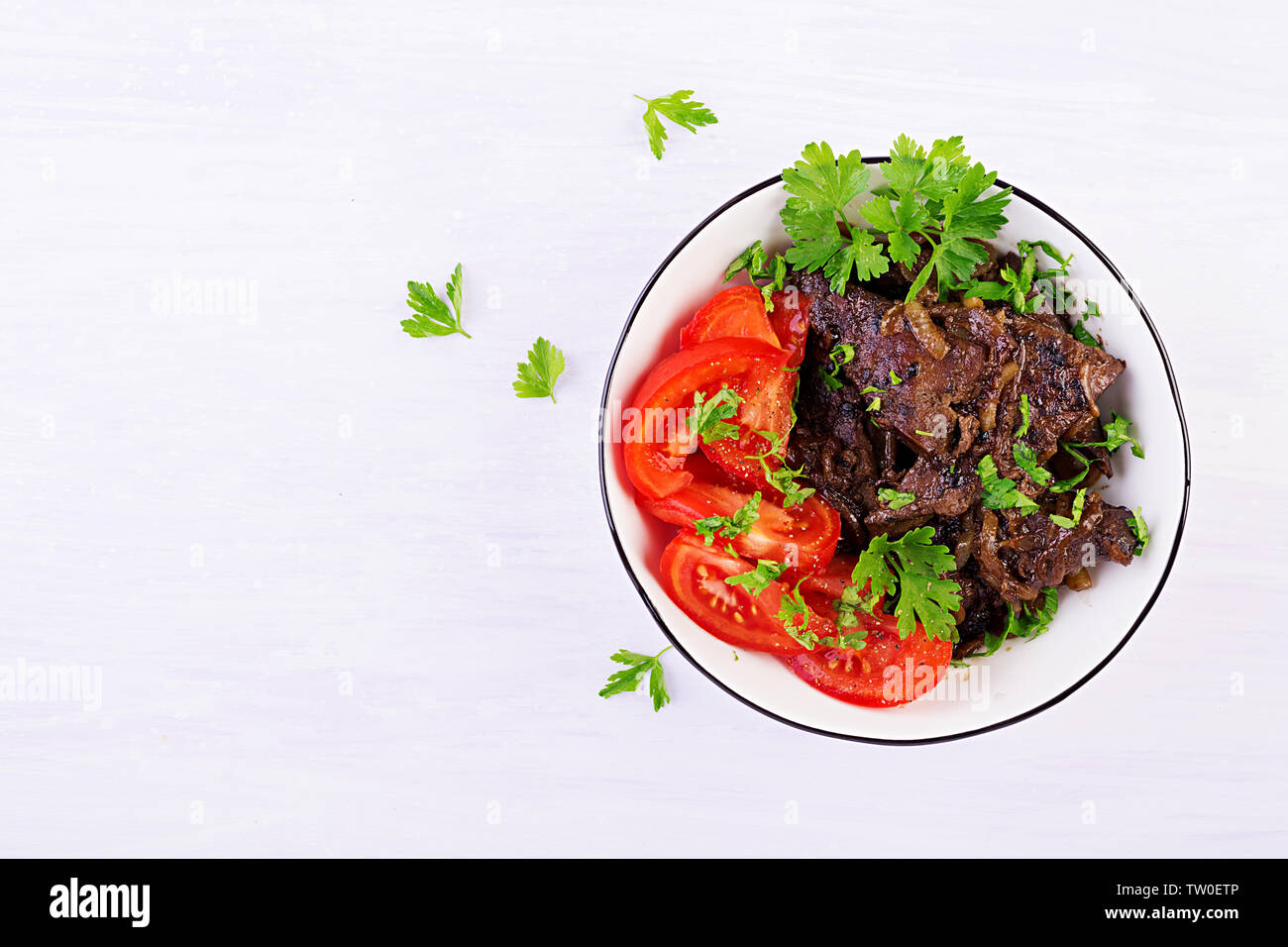 Roasted or grilled beef liver with onion and tomatoes salad. Middle ...