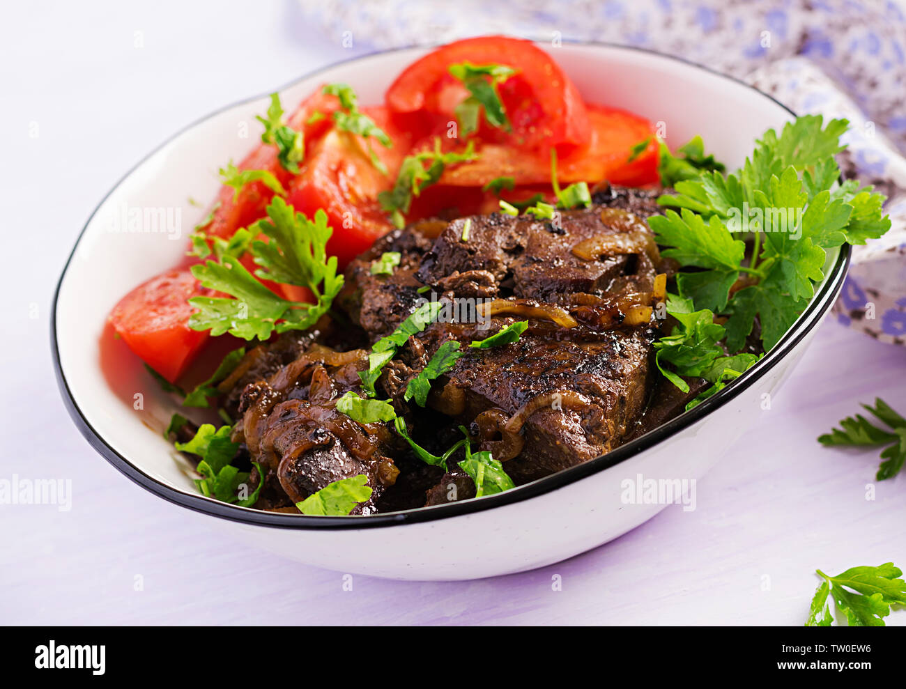 Roasted or grilled beef liver with onion and tomatoes salad. Middle ...