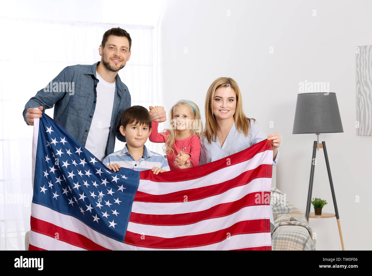 Happy family with American flag at home Stock Photo - Alamy