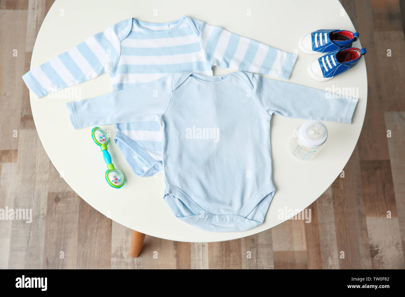 Set of baby clothes on light table Stock Photo - Alamy