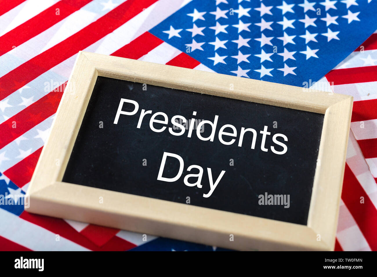 the text happy presidents day written in a chalkboard and a flag of the ...