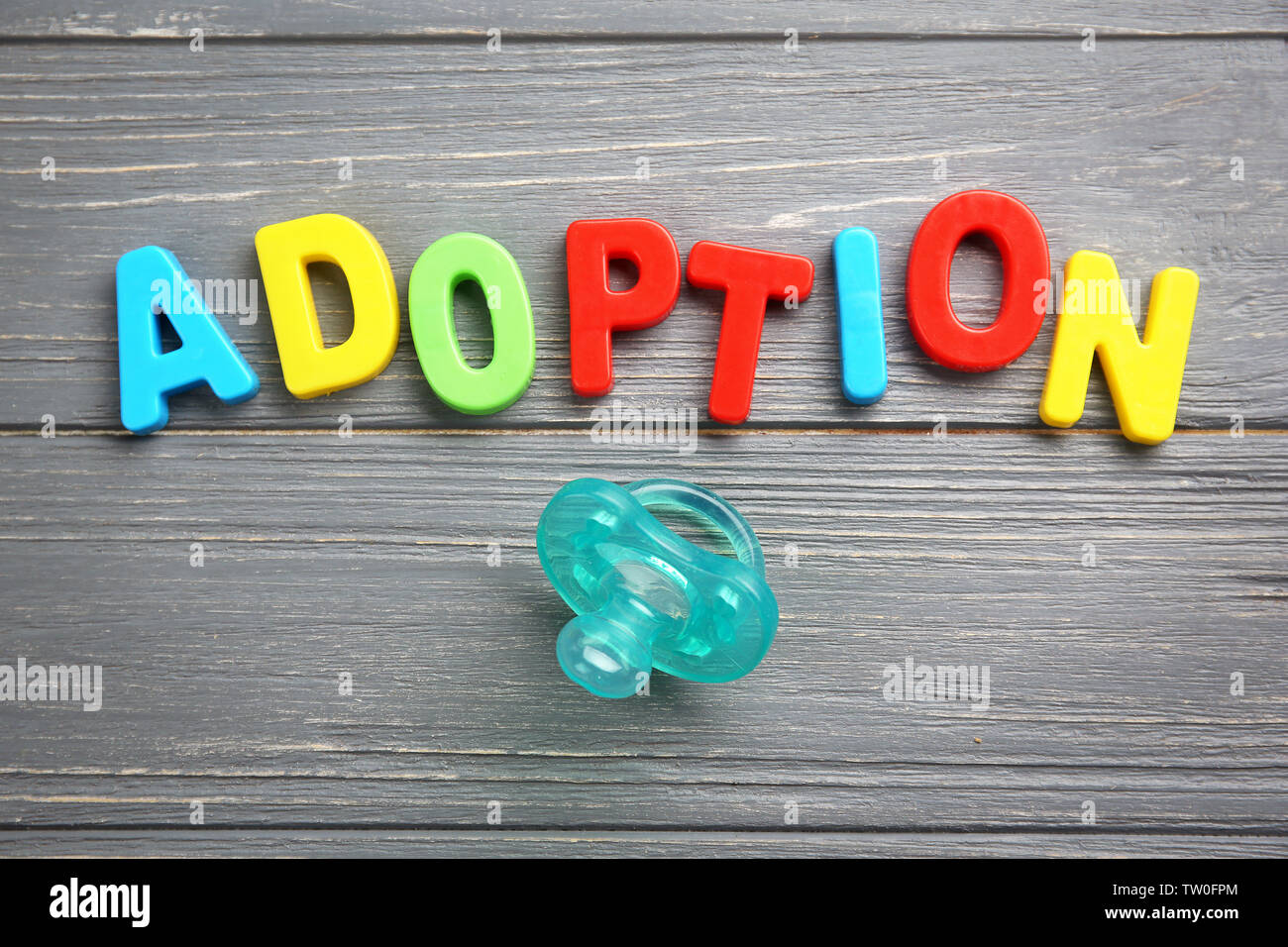 Word ADOPTION and passifier on wooden background Stock Photo - Alamy