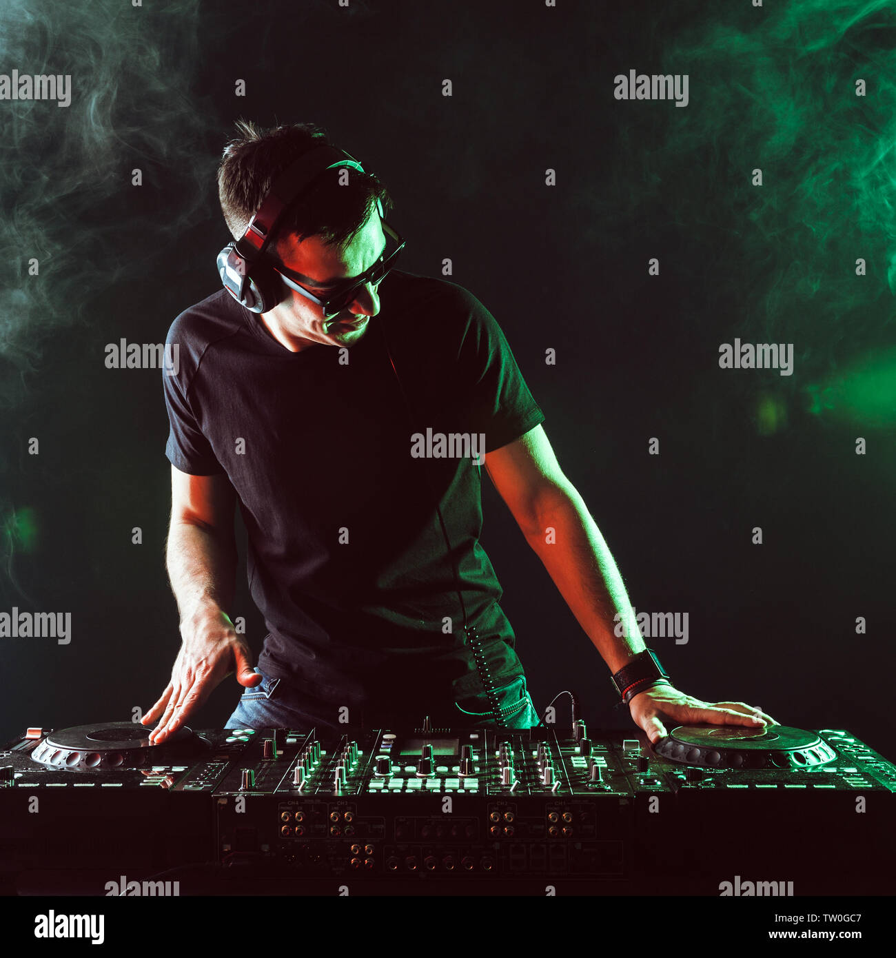 DJ mixing music on mixer on dark background Stock Photo - Alamy