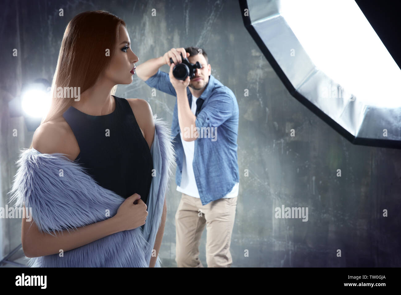 Young beautiful model posing for professional photographer in studio ...