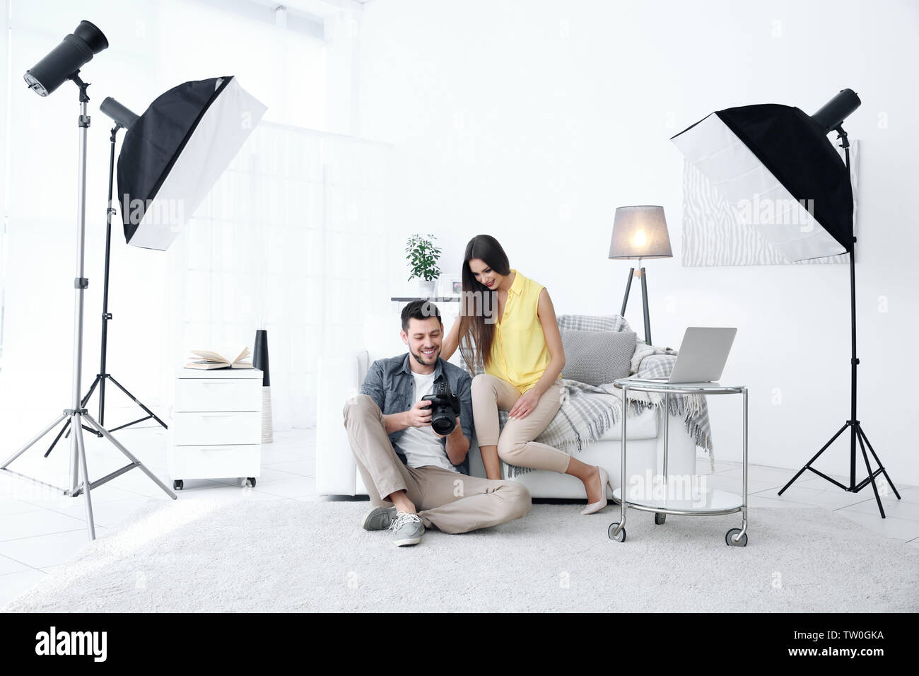 Photographer and model in professional studio discussing picture on ...