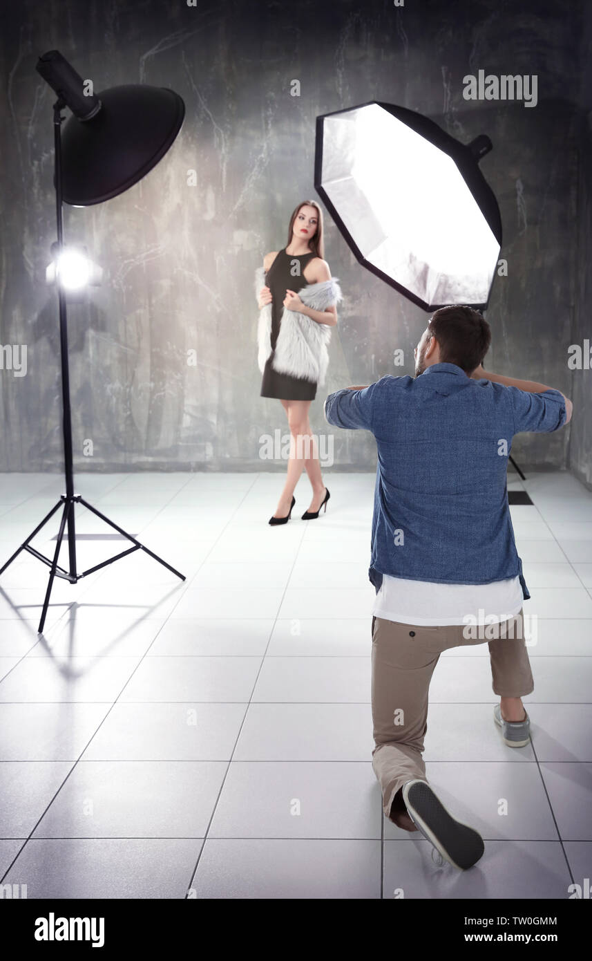 Young beautiful model posing for professional photographer in studio ...