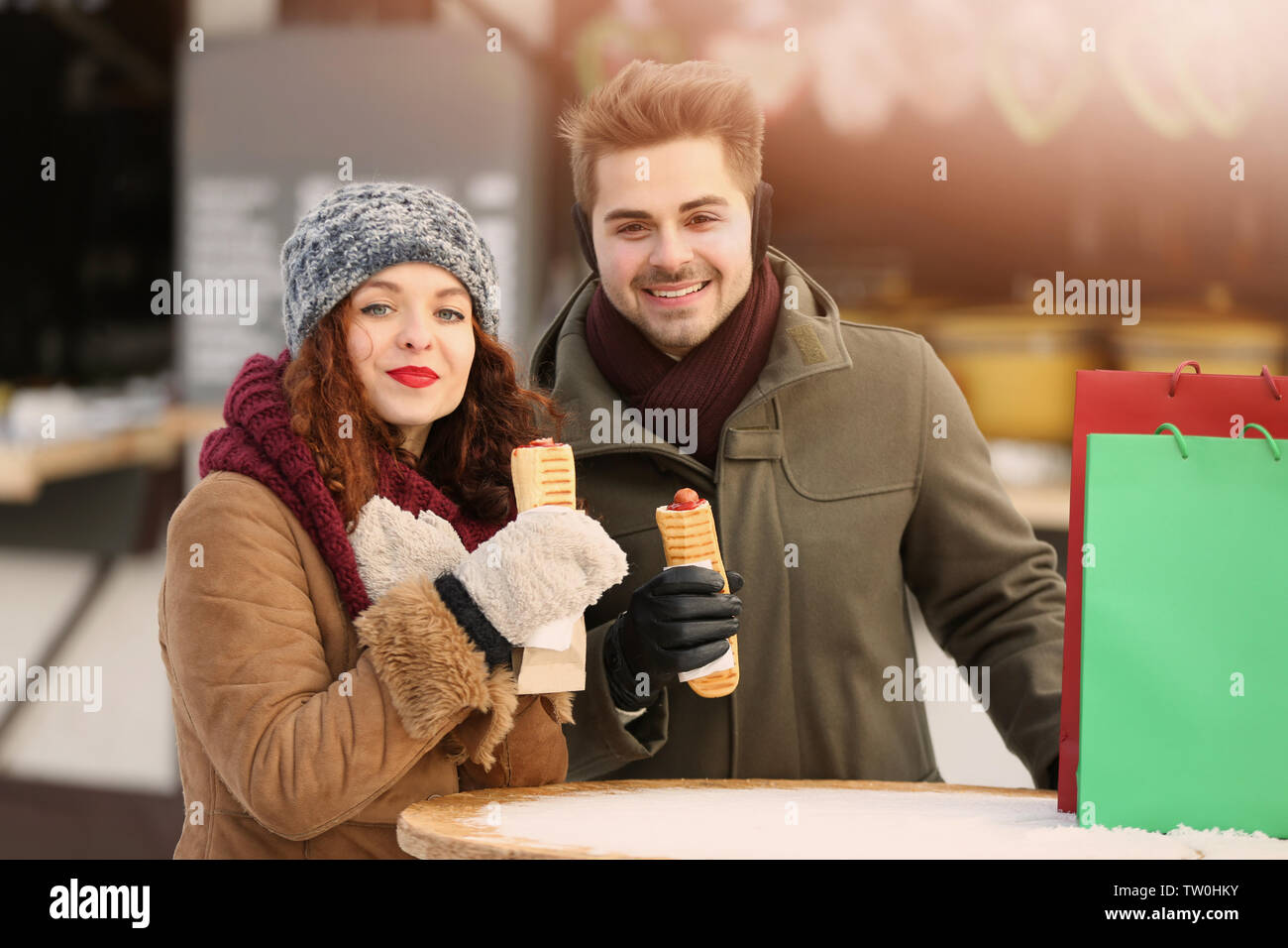 Cute couple having lunch break on winter market Stock Photo - Alamy